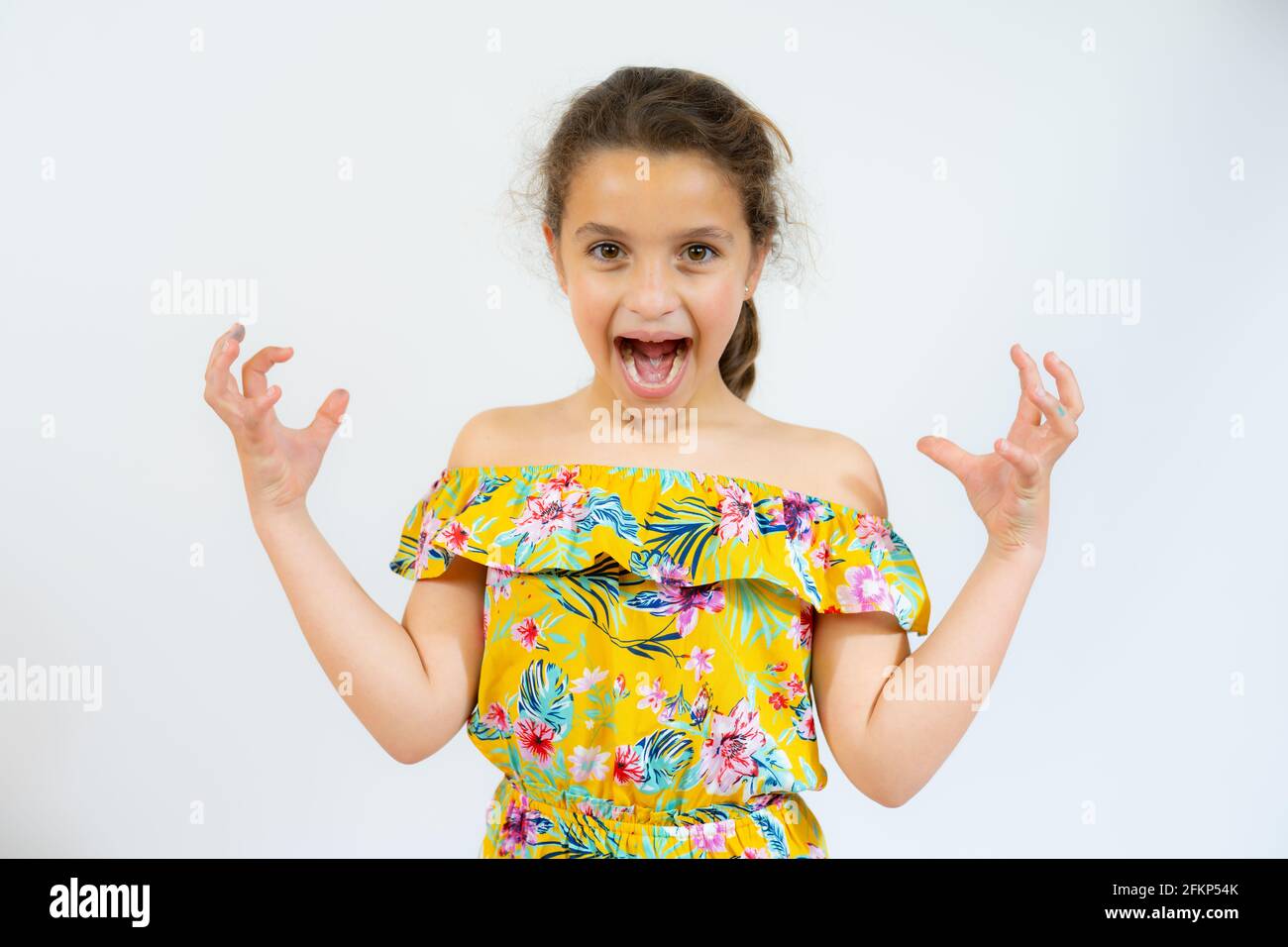Hispanic little girl crazy and mad shouting and yelling with arms ...