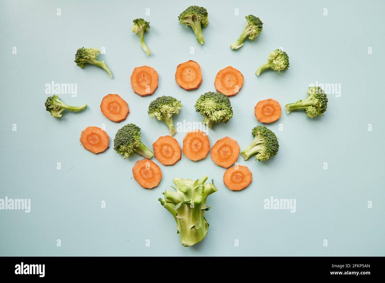 Vegan food concept. Explosion of carrots and broccoli on blue ...
