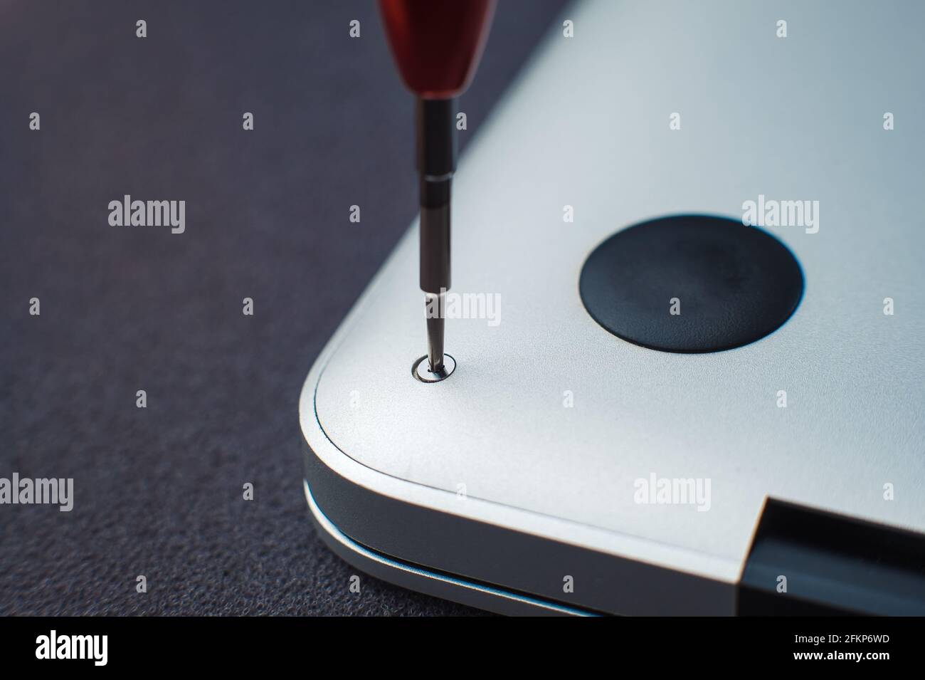 Master unscrewing small screw with magnetic screwdriver tool of broken ...