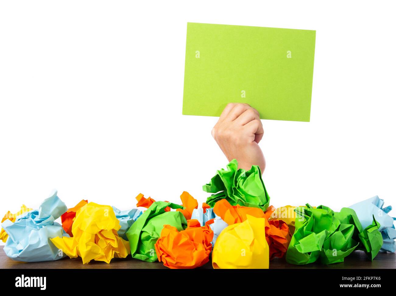Hand holding a green paper comimg out from the crumble paper Stock ...