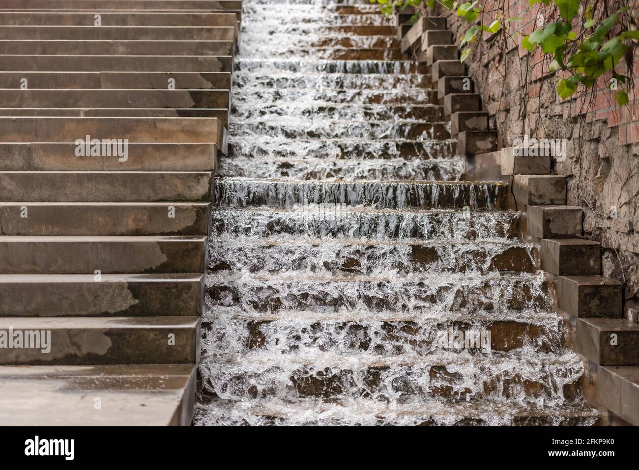 Street fountain on the stairs. Water runs down the stairs in the ...