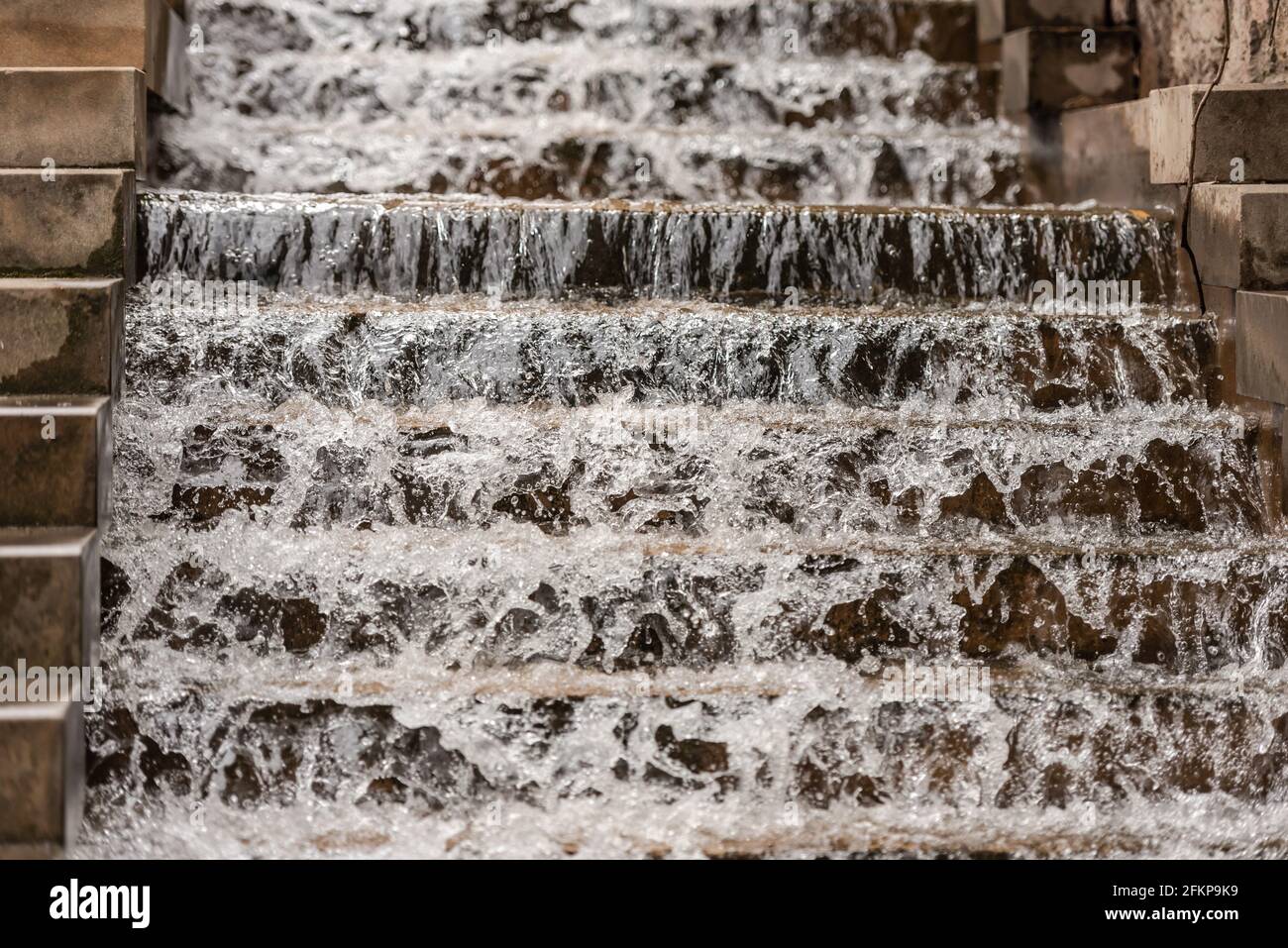 Street fountain on the stairs. Water runs down the stairs in the ...