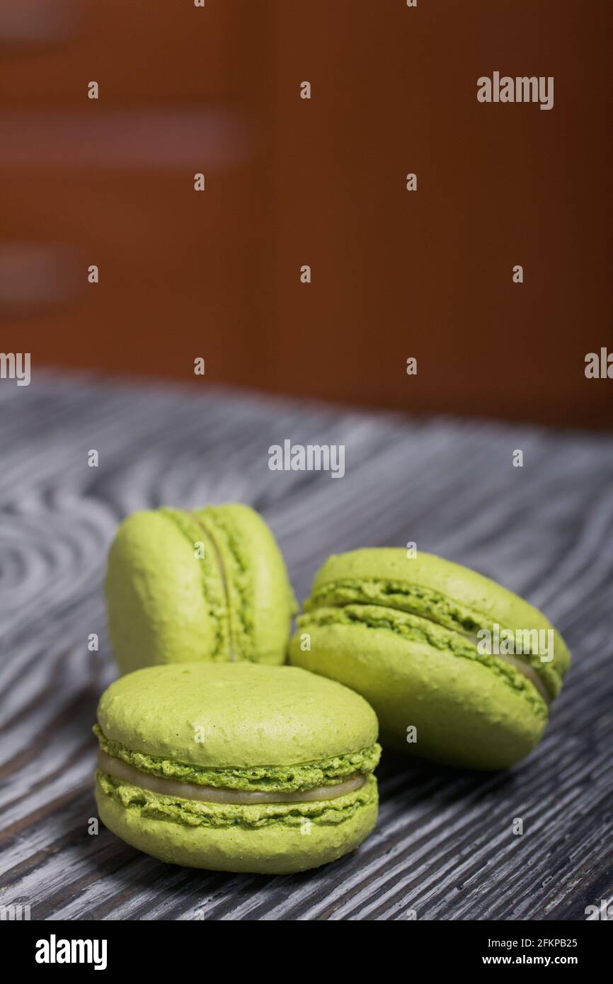 Macarons cakes light green color. They lie on black and white pine ...