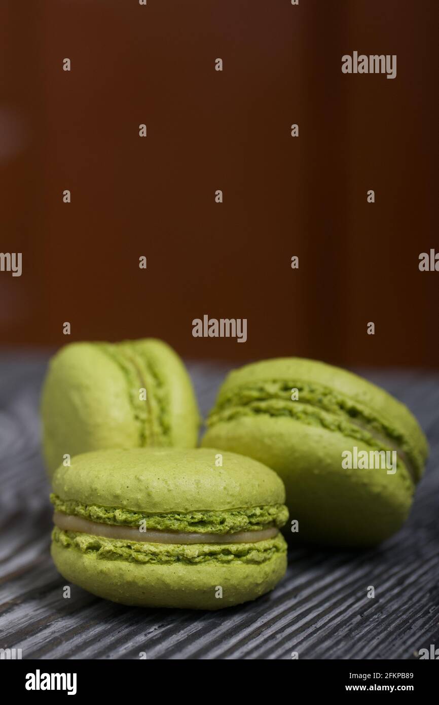 Macarons cakes light green color. They lie on black and white pine ...