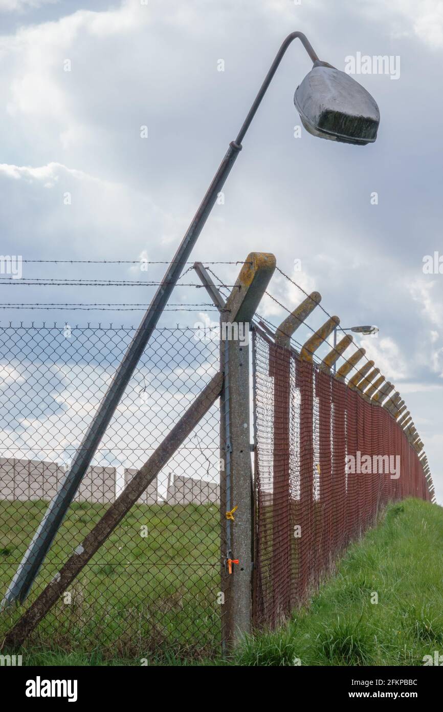 mesh and barbed wire perimeter fence around an army compound on ...
