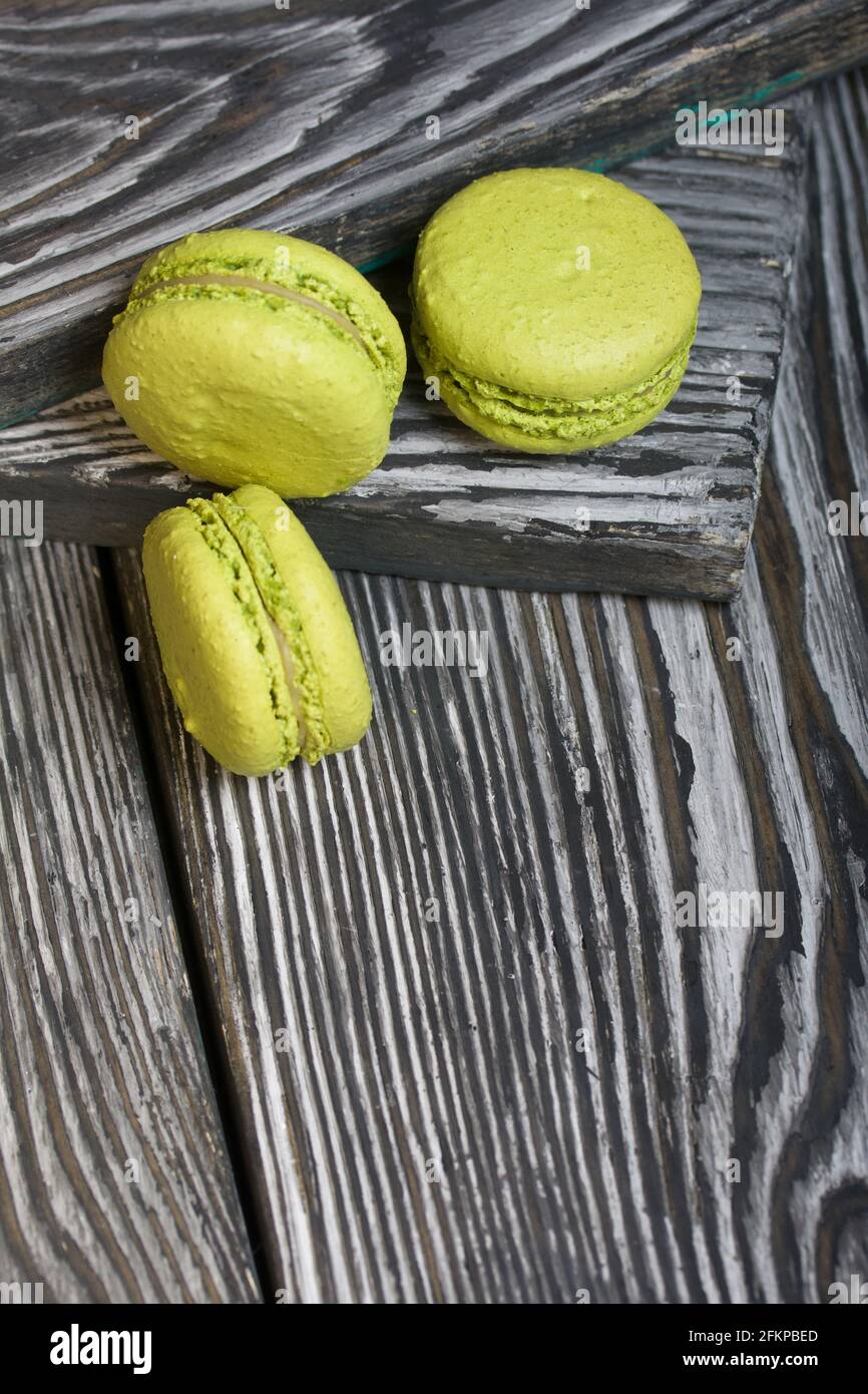 Macarons cakes light green color. They lie on black and white pine ...