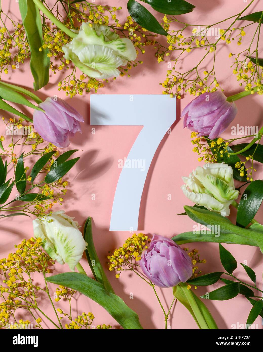 Number seven on pink background with colorful flowers. Flat lay, top ...