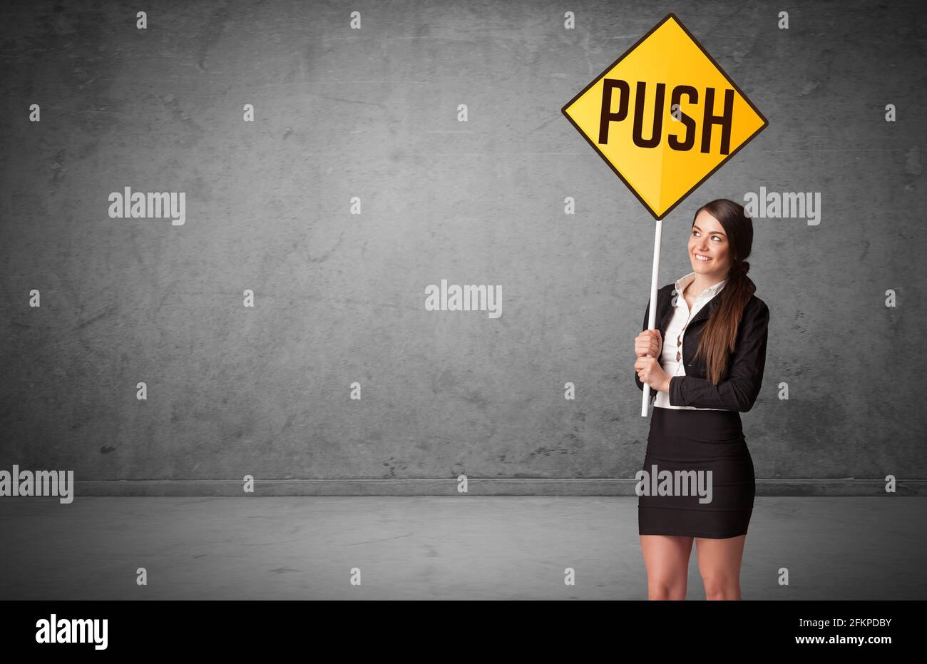 Young business person holding road sign Stock Photo - Alamy