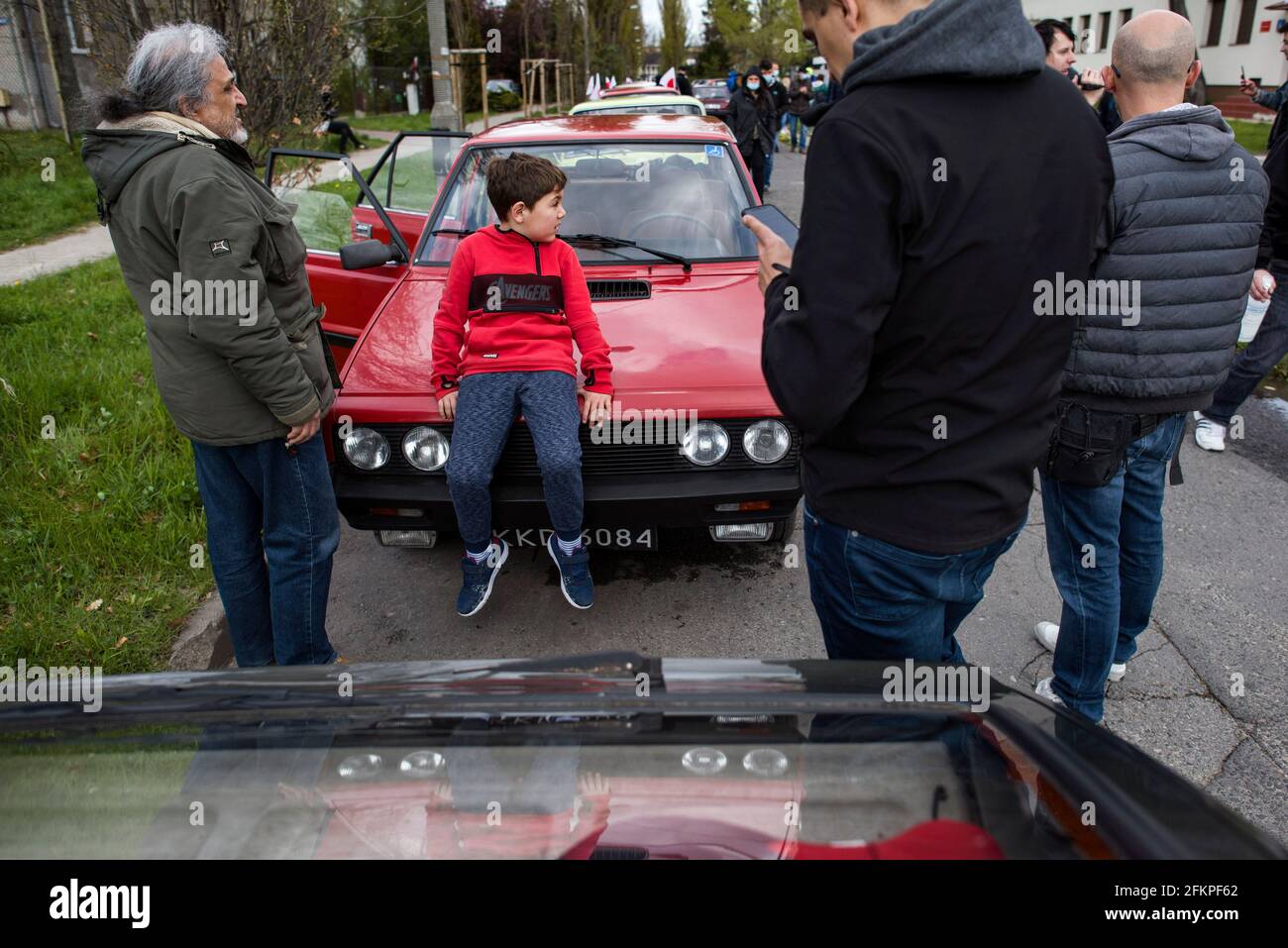 A kid is sitting on the hood of a classic Polonez during the rally ...