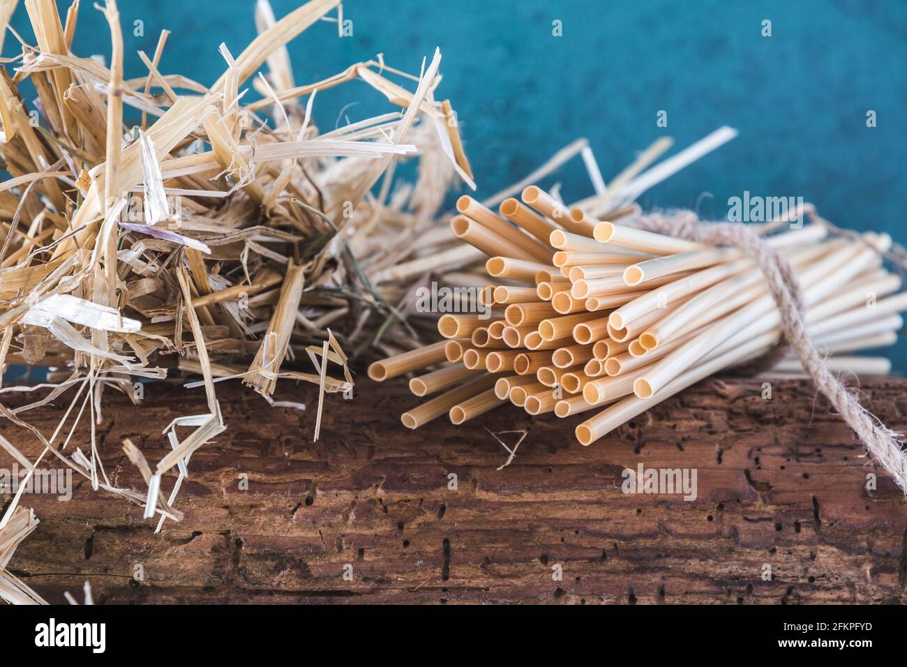 Natural straw drinking straws and a bundle of straw on an old wooden ...