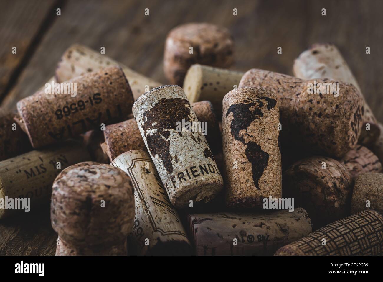 Two corks on a pile of used corks which show a world map and the word ...
