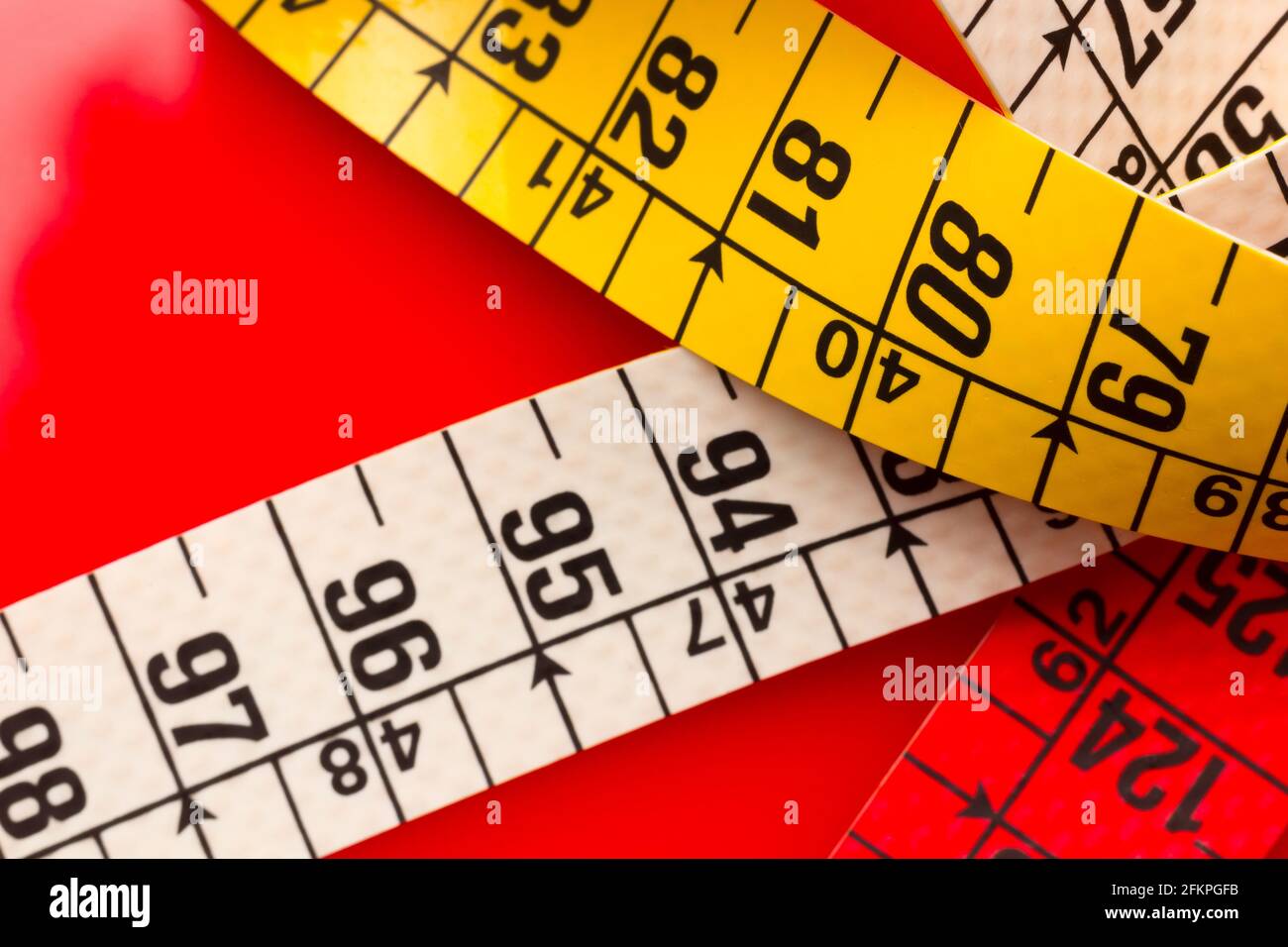 Yellow tape measure for measuring perimeters of objects; tailor's and ...