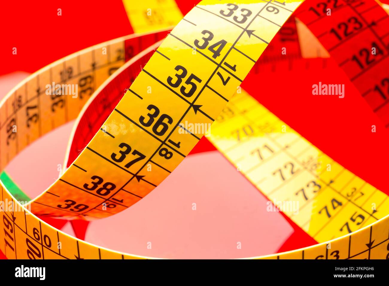Yellow tape measure for measuring perimeters of objects; tailor's and ...