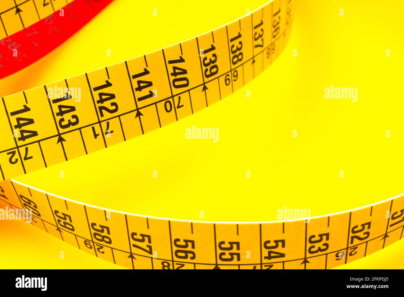Yellow tape measure for measuring perimeters of objects; tailor's and ...