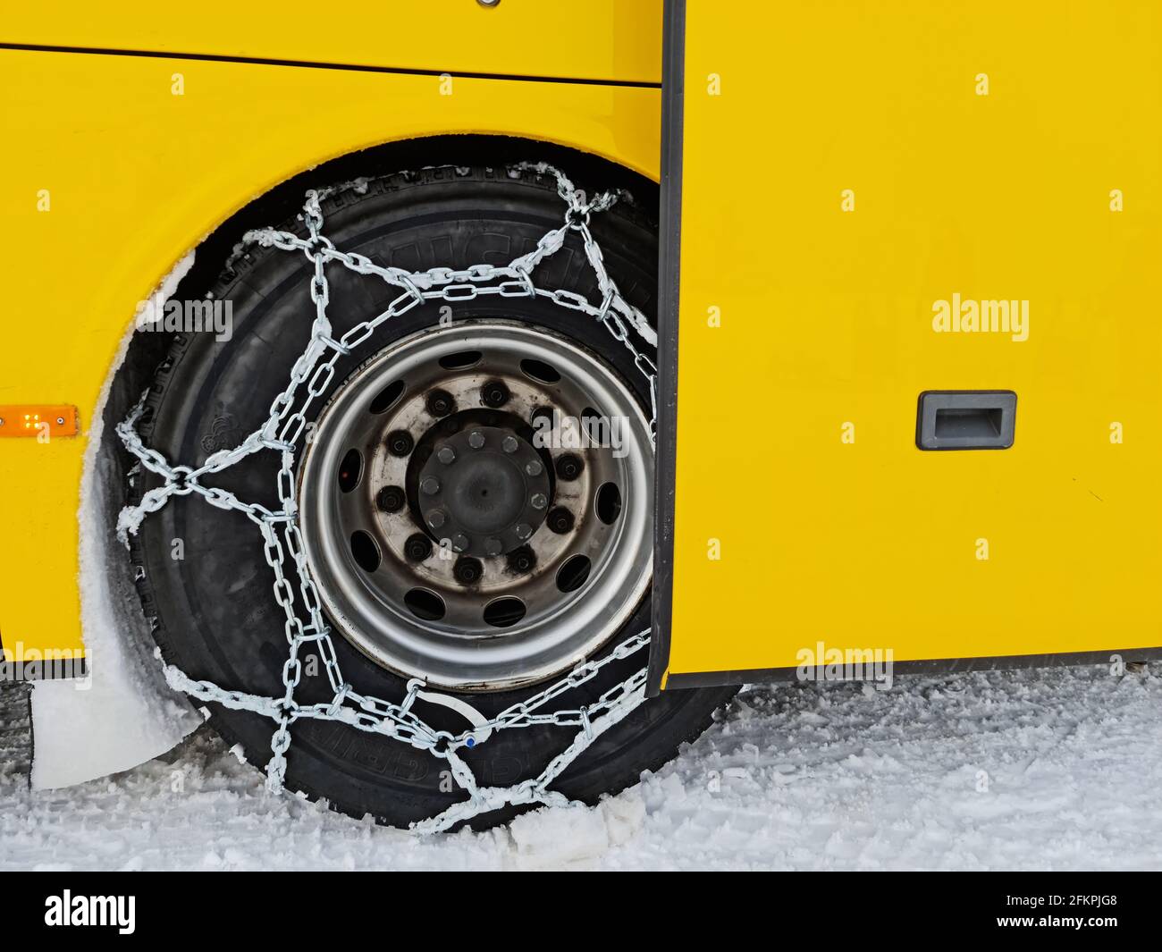 Postal bus with chains on a tire for safety Stock Photo - Alamy