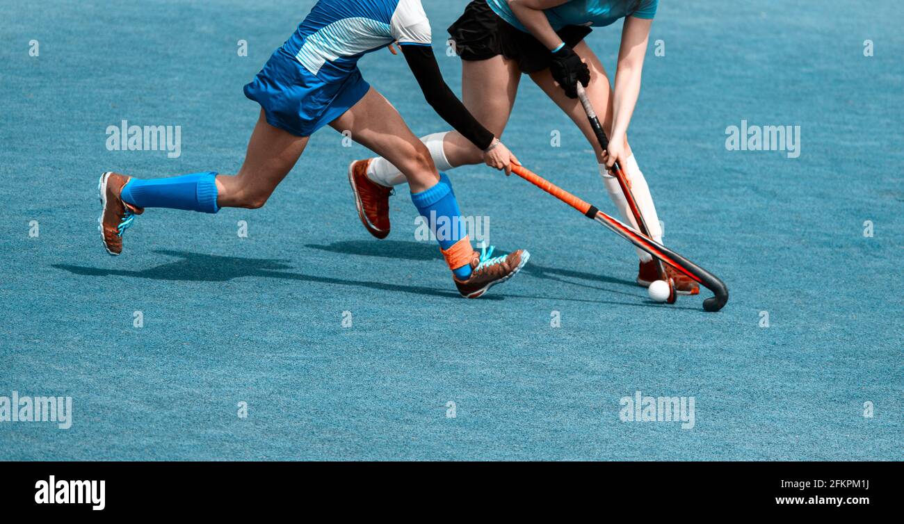 Two field hockey player, fighting for the ball on the midfield during ...