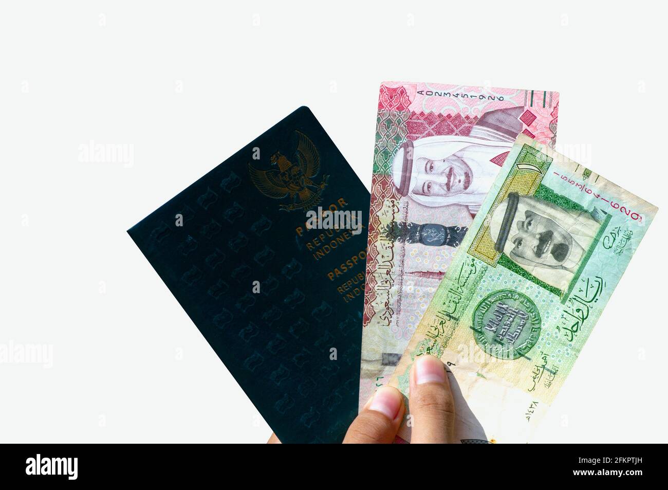 Indonesian green passport book and The Saudi Riyal, the currency of ...