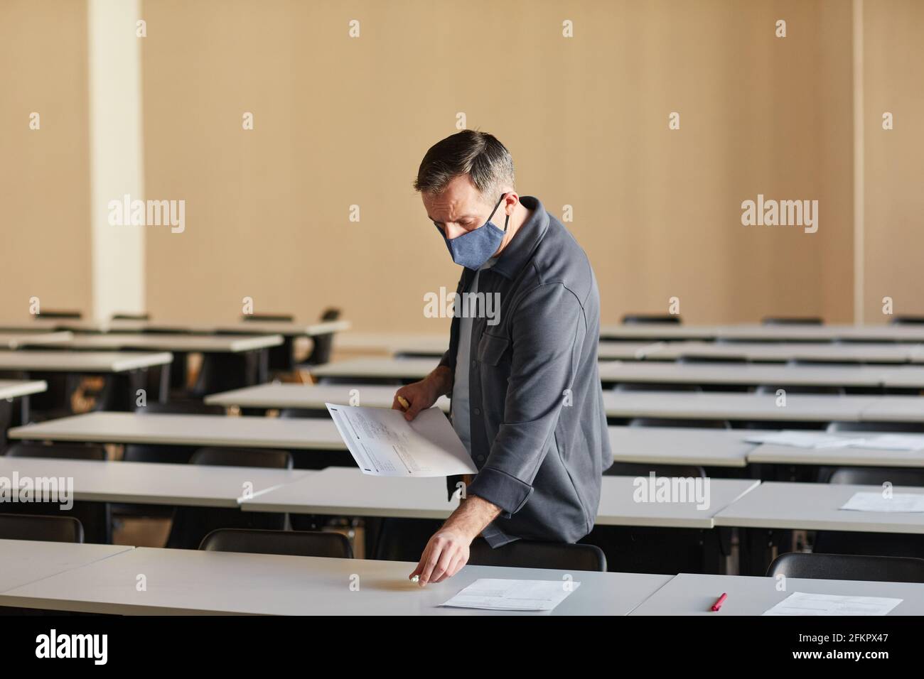 Wide angle portrait of mature college professor wearing mask while ...