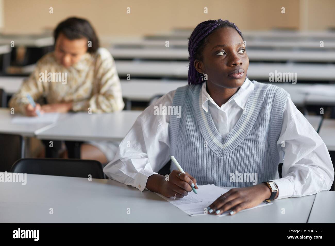 Portrait of young African-American woman taking exam in school ...