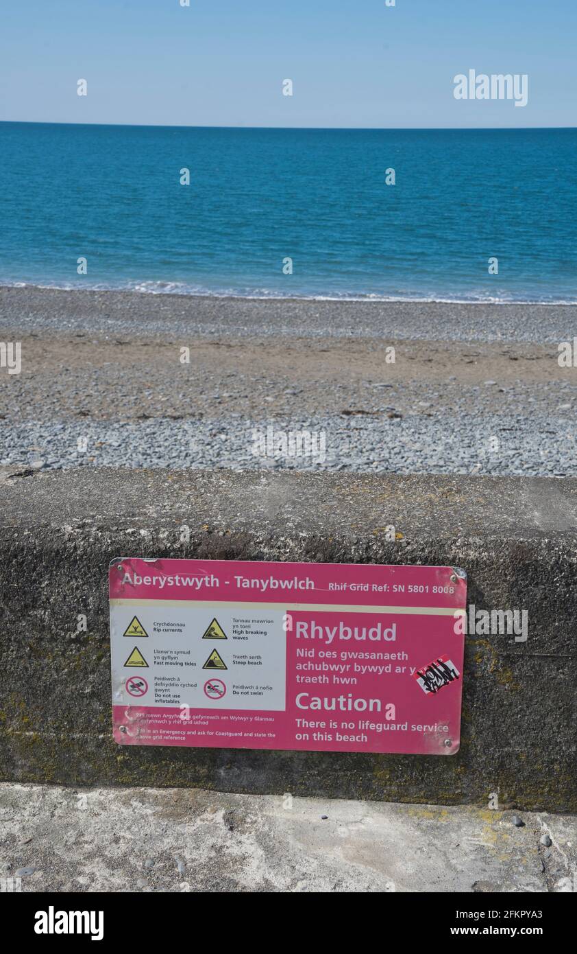 Beach with pebbles,rocks and stacked limestone strata in Ceredigion ...