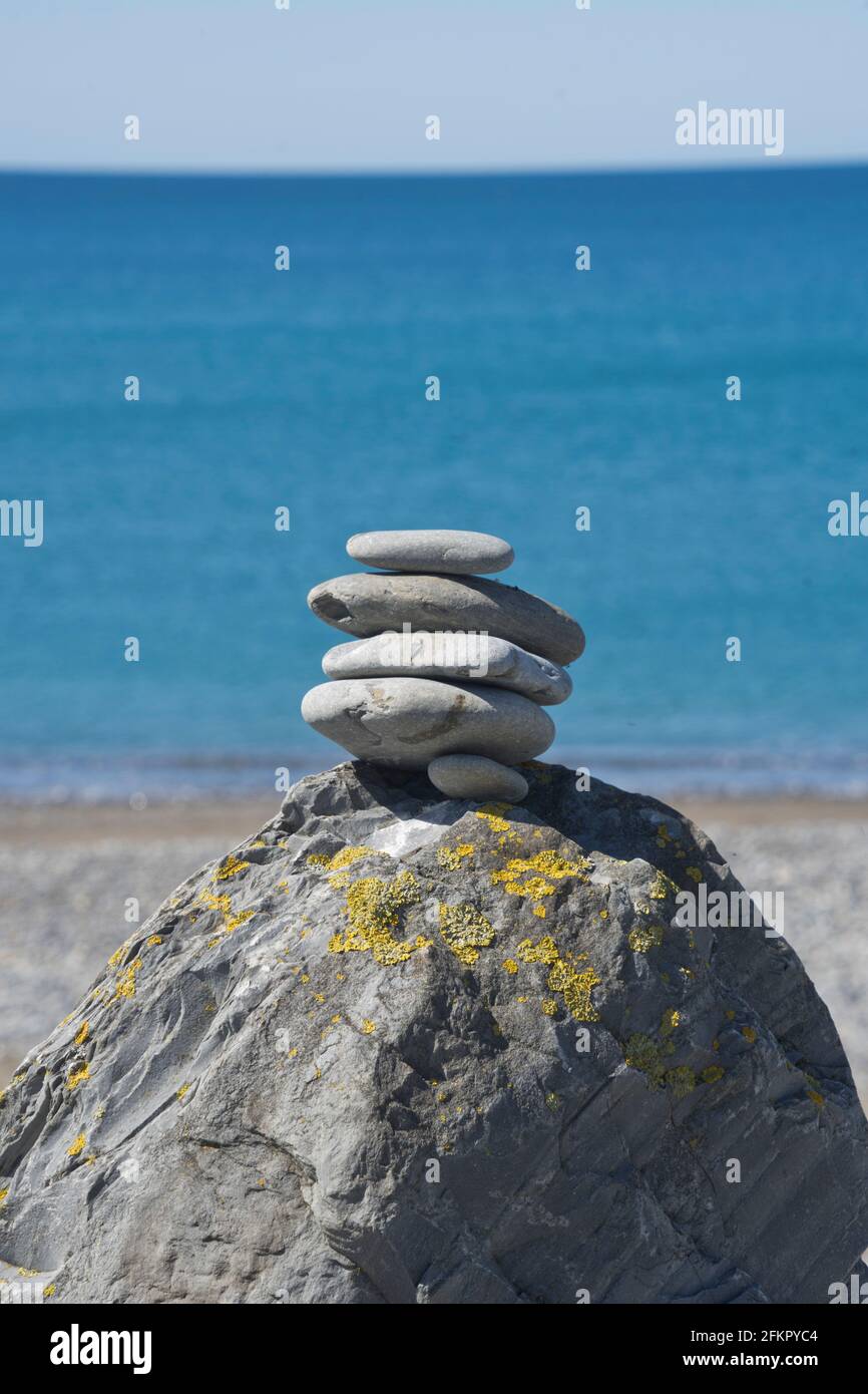 Beach with pebbles,rocks and stacked limestone strata in Ceredigion ...