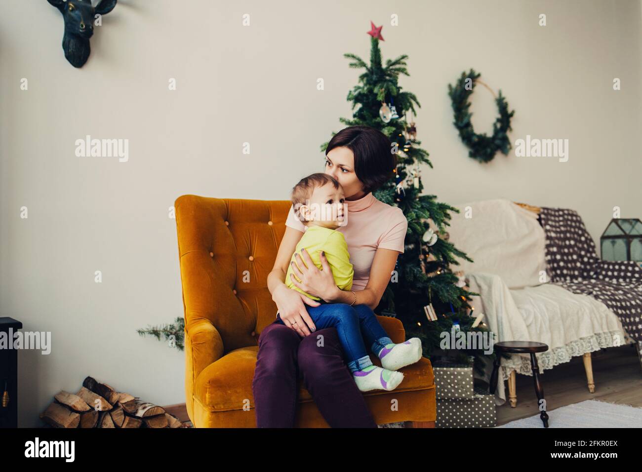 Mother and daughter sitting in a chair in an embrace. family happiness ...