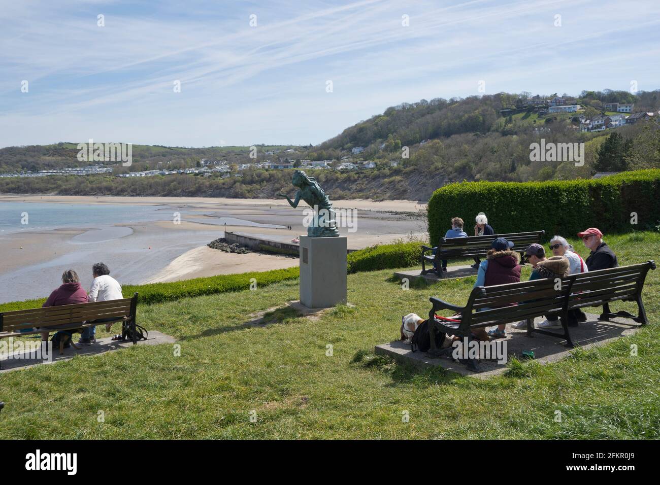 Visitors by mermaid statue on the beach in the harbour of the coastal ...