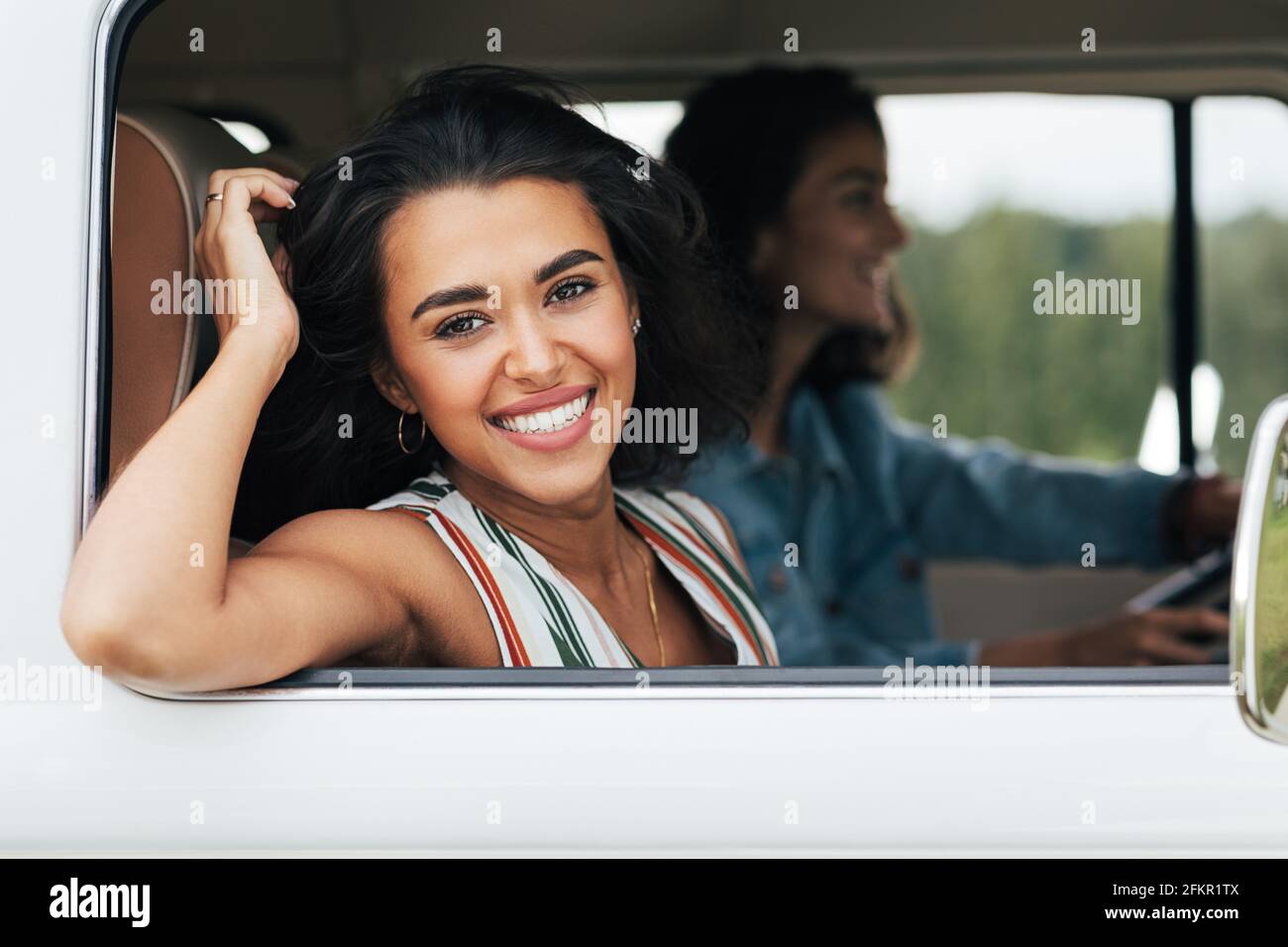 Happy woman sitting on a passenger seat in minivan and looking at ...