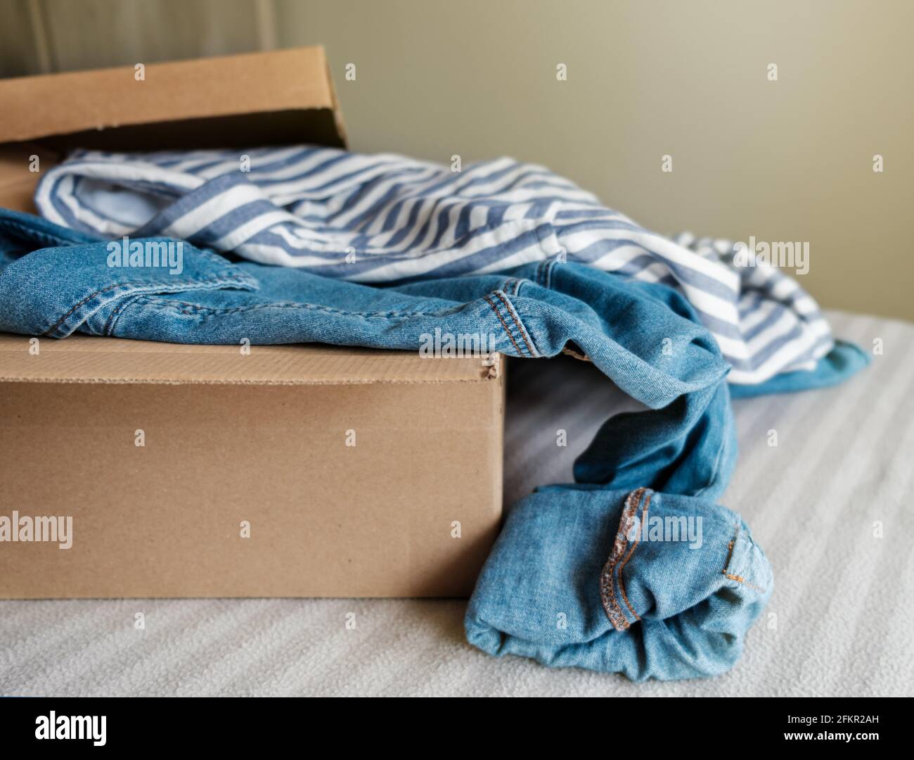 Cardboard box with pre owned clothes inside Stock Photo - Alamy