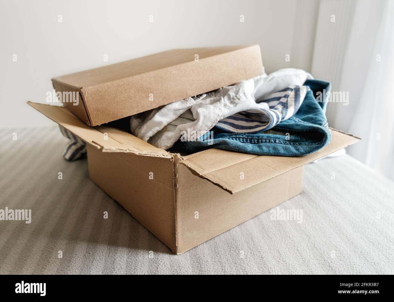 Cardboard box with pre owned clothes inside Stock Photo - Alamy