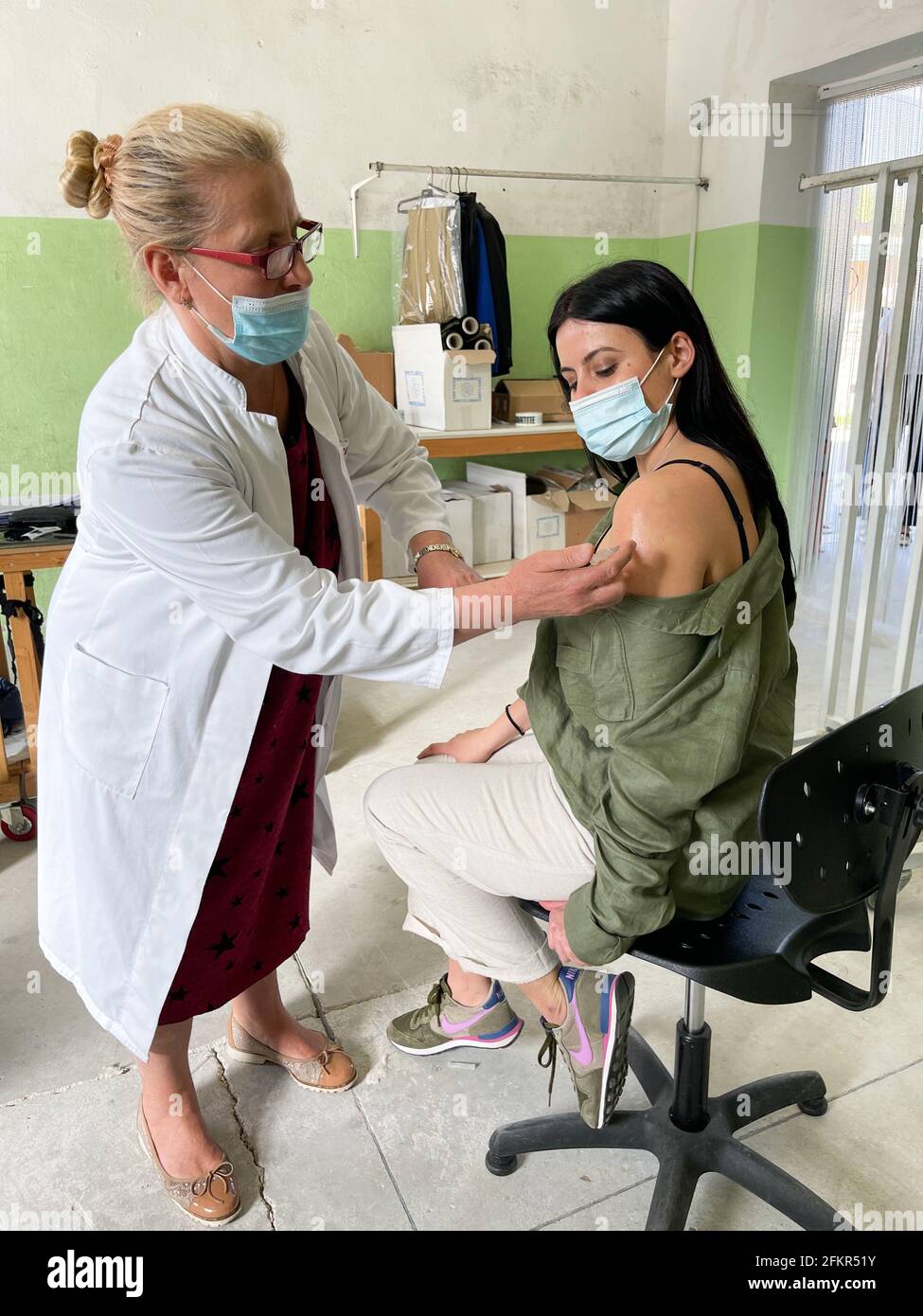 Woman receiving an injection in her arm Stock Photo - Alamy