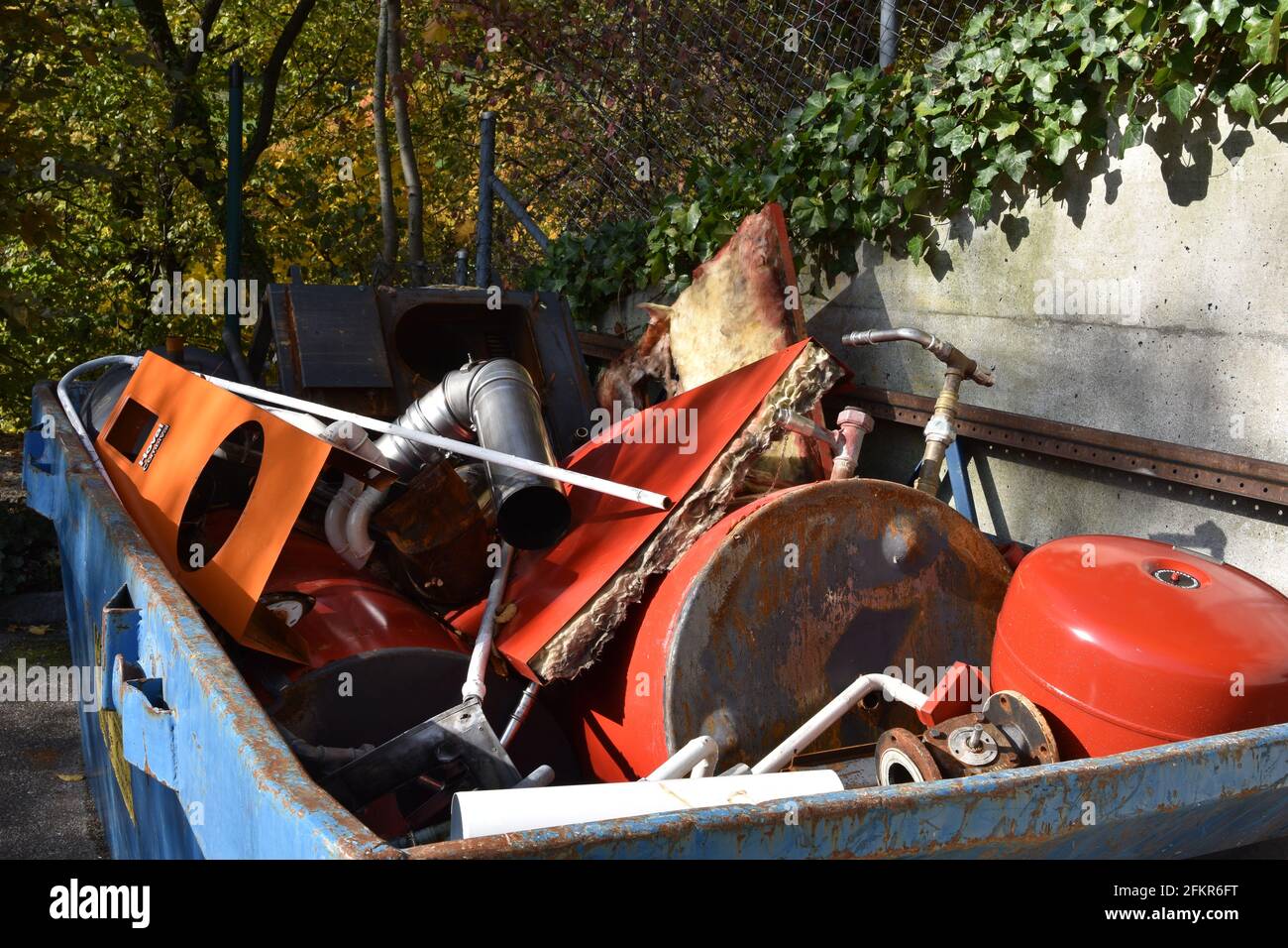 Scrap metal collected in a container in a community disposal place. A ...