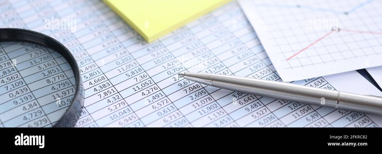 Papers with digital indicators magnifier and pen Stock Photo - Alamy