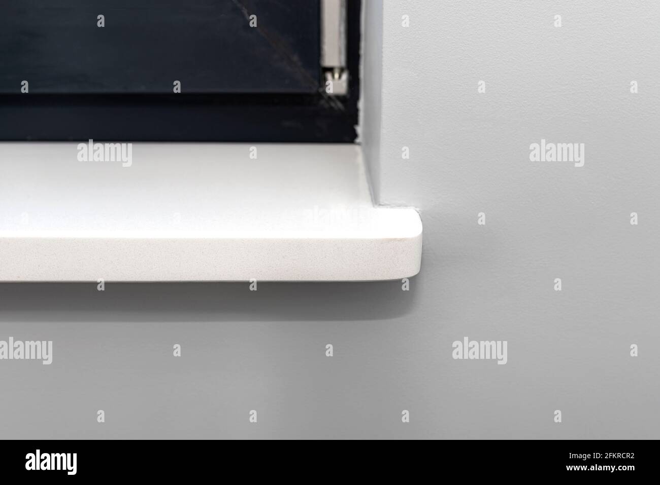 Newly installed white conglomerate window sill inside the room, on the ...