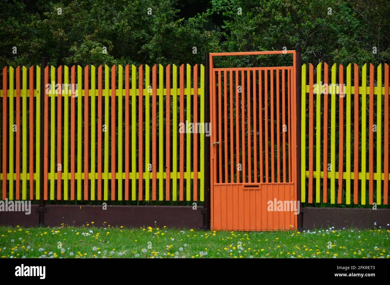 Closeup shot of a colorful fence and orange door, yellow and orange ...