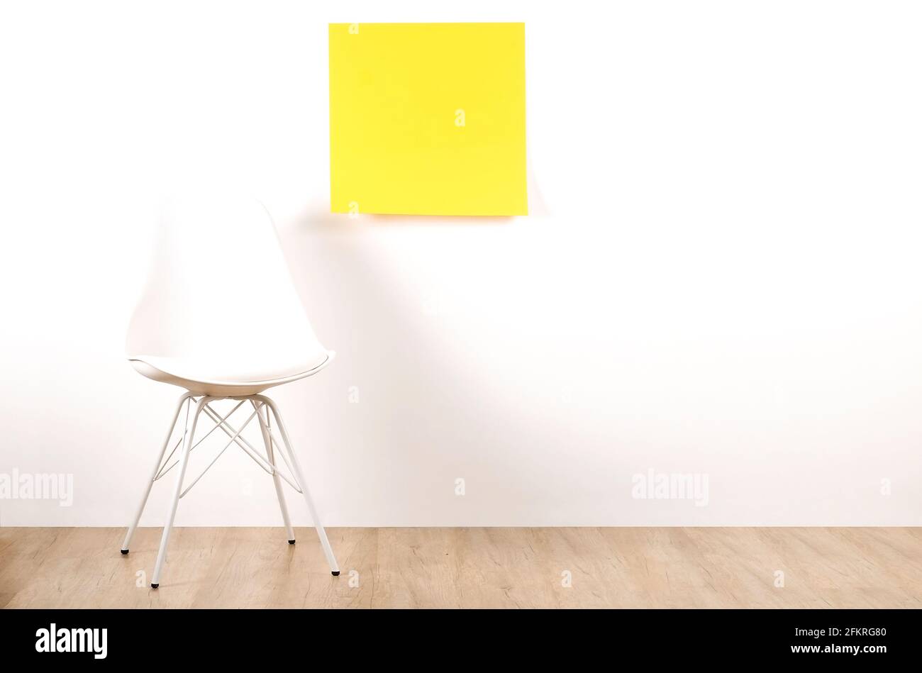 Single empty loft style chair on wooden floor with blank ad poster and ...