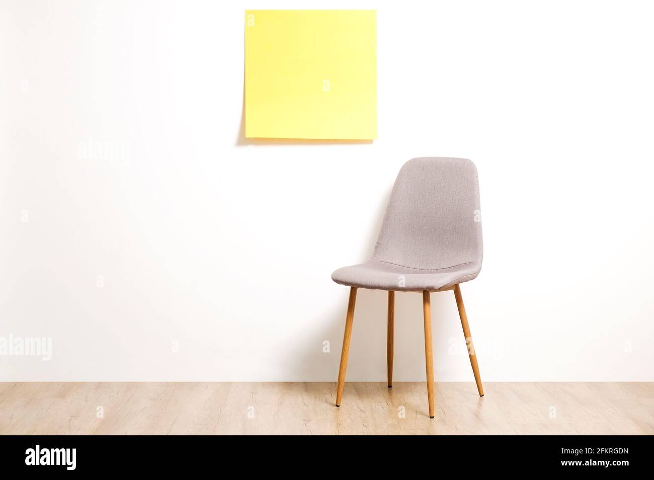 Single empty loft style gray chair on wooden floor, blank ad poster and ...