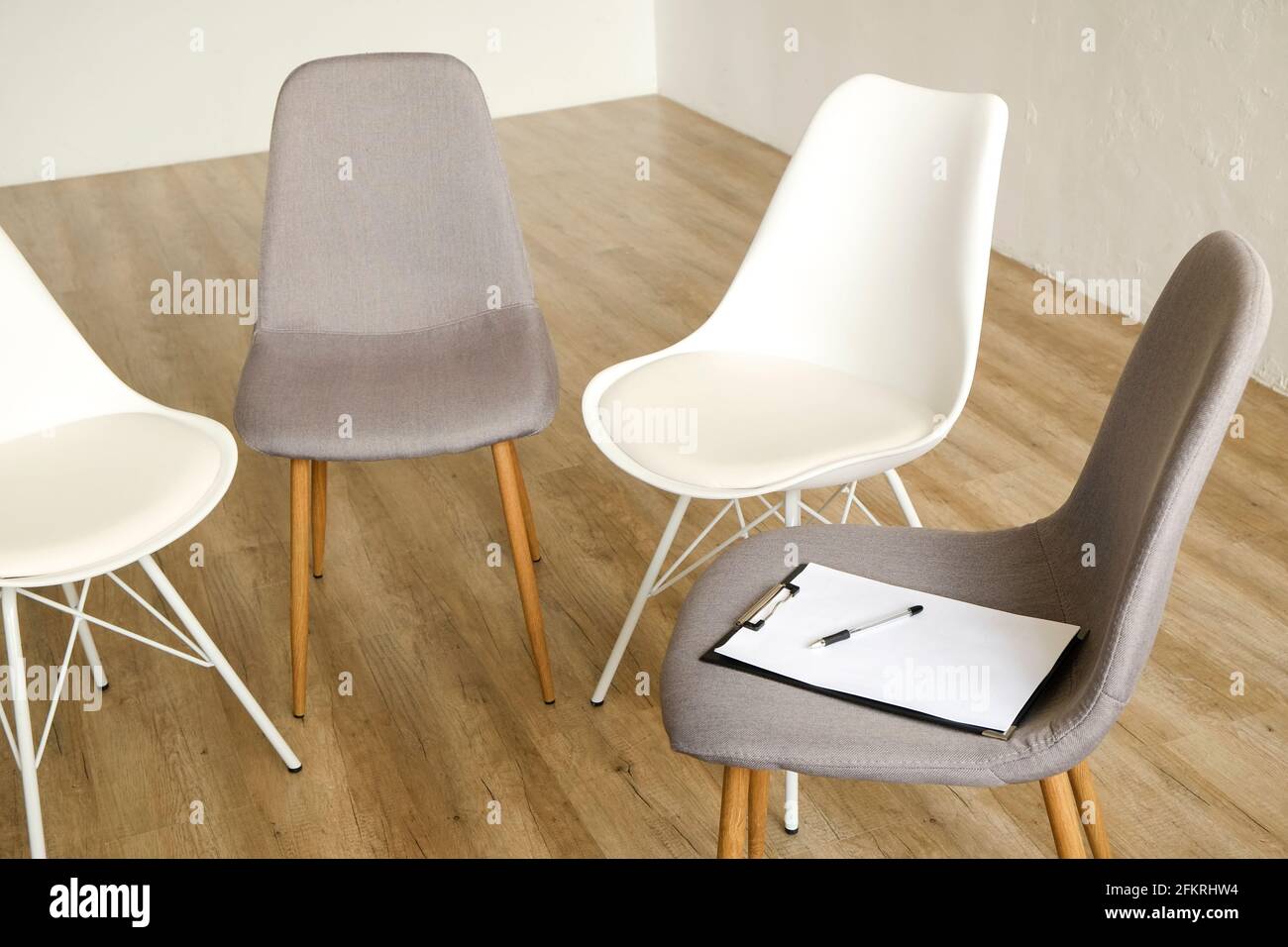 Multiple loft style empty chairs standing in row on wooden floor ...