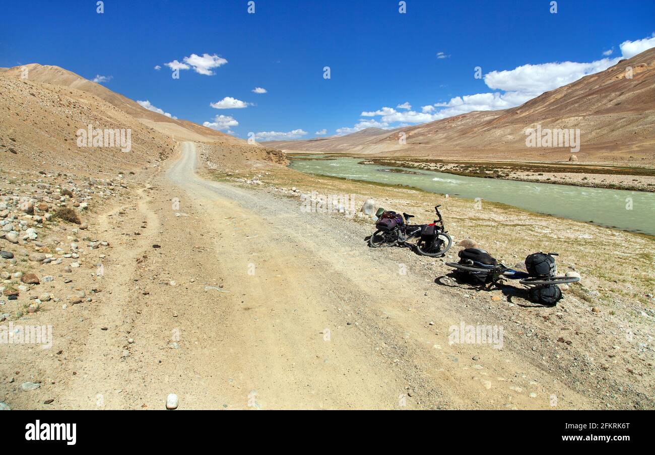 Pamir river, Pamir mountains, unpaved road and two bicycle. Tajikistan ...
