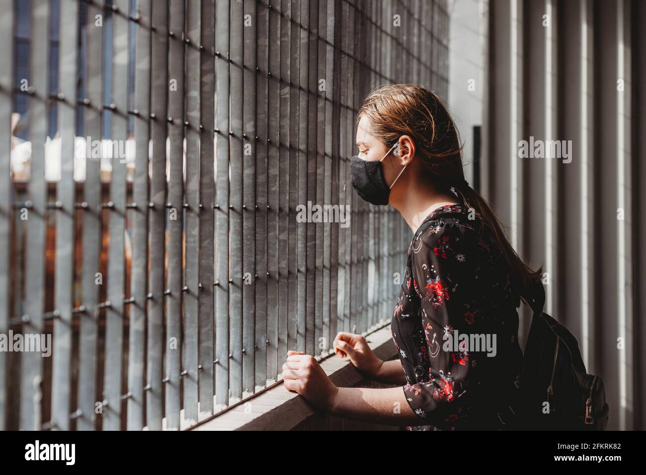 sad women with face mask behind the metal bars, lockdown concept Stock ...