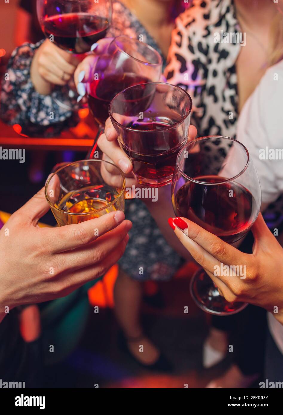 Clinking glasses with alcohol and toasting, party Stock Photo - Alamy
