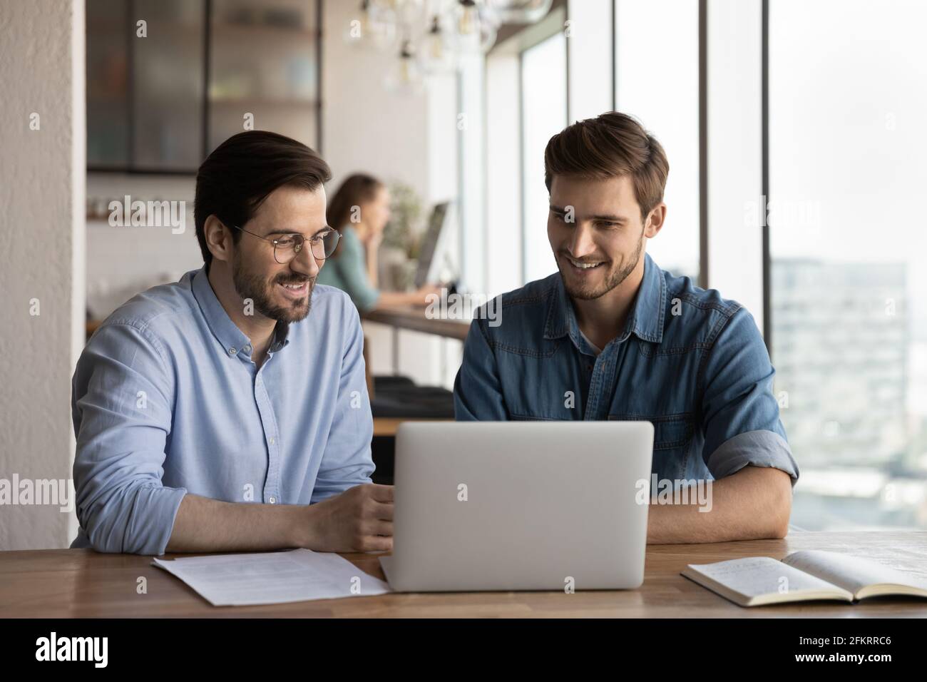 Smiling male colleagues cooperate together on laptop Stock Photo - Alamy