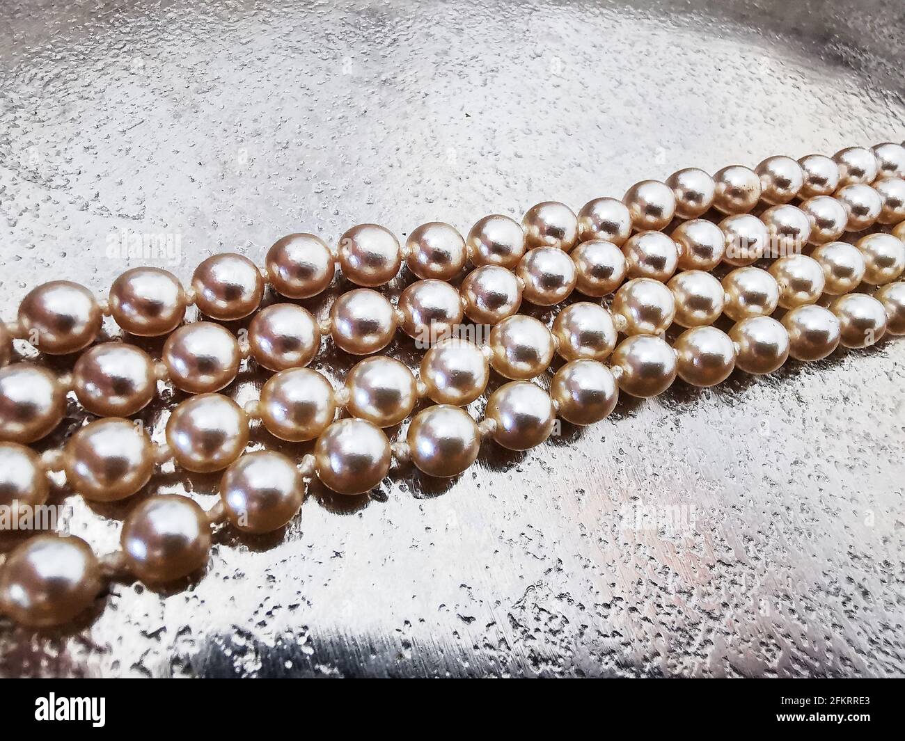 Closeup shot of beautiful pearl beads on a shiny metal surface Stock ...