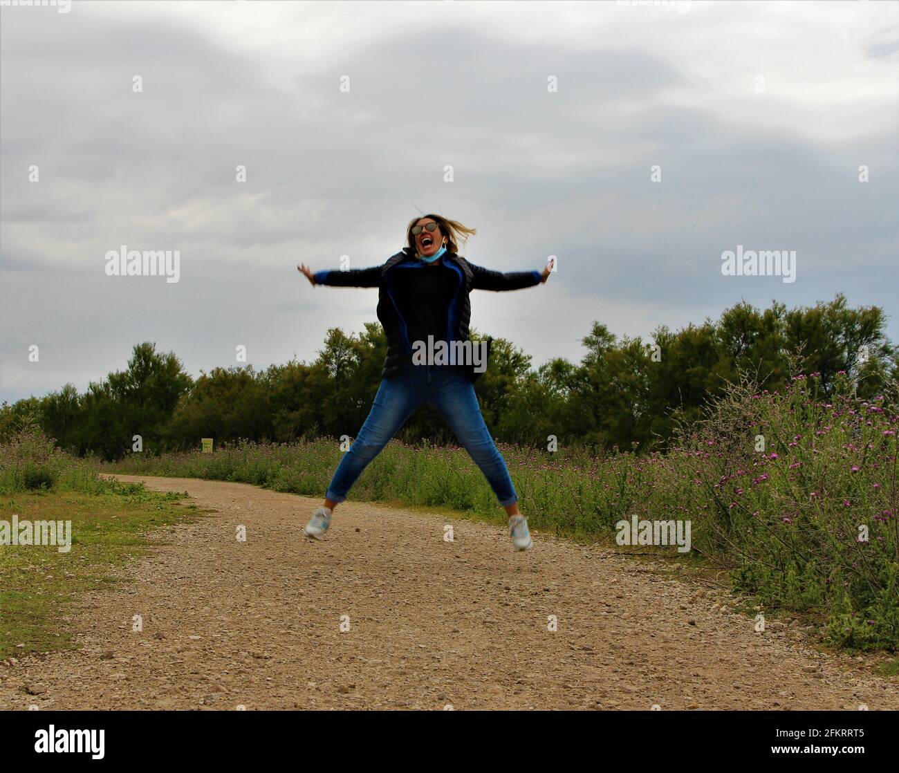 Closeup shot of a female jumping on the narrow pathway in nature Stock ...