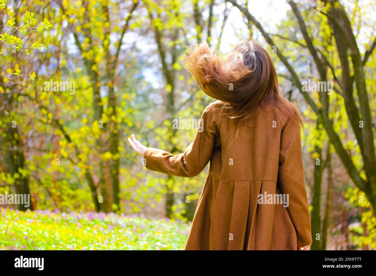 Back view of a young elegant lady girl at spring forest, park. A girl ...