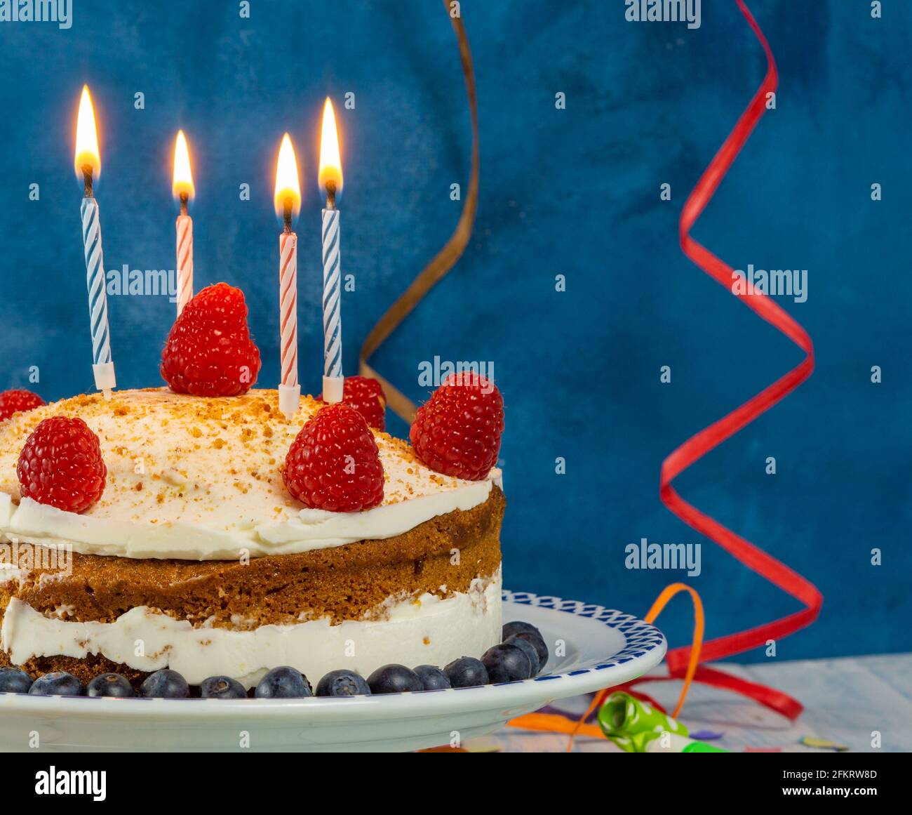 birthday cake with candles and streamer Stock Photo - Alamy