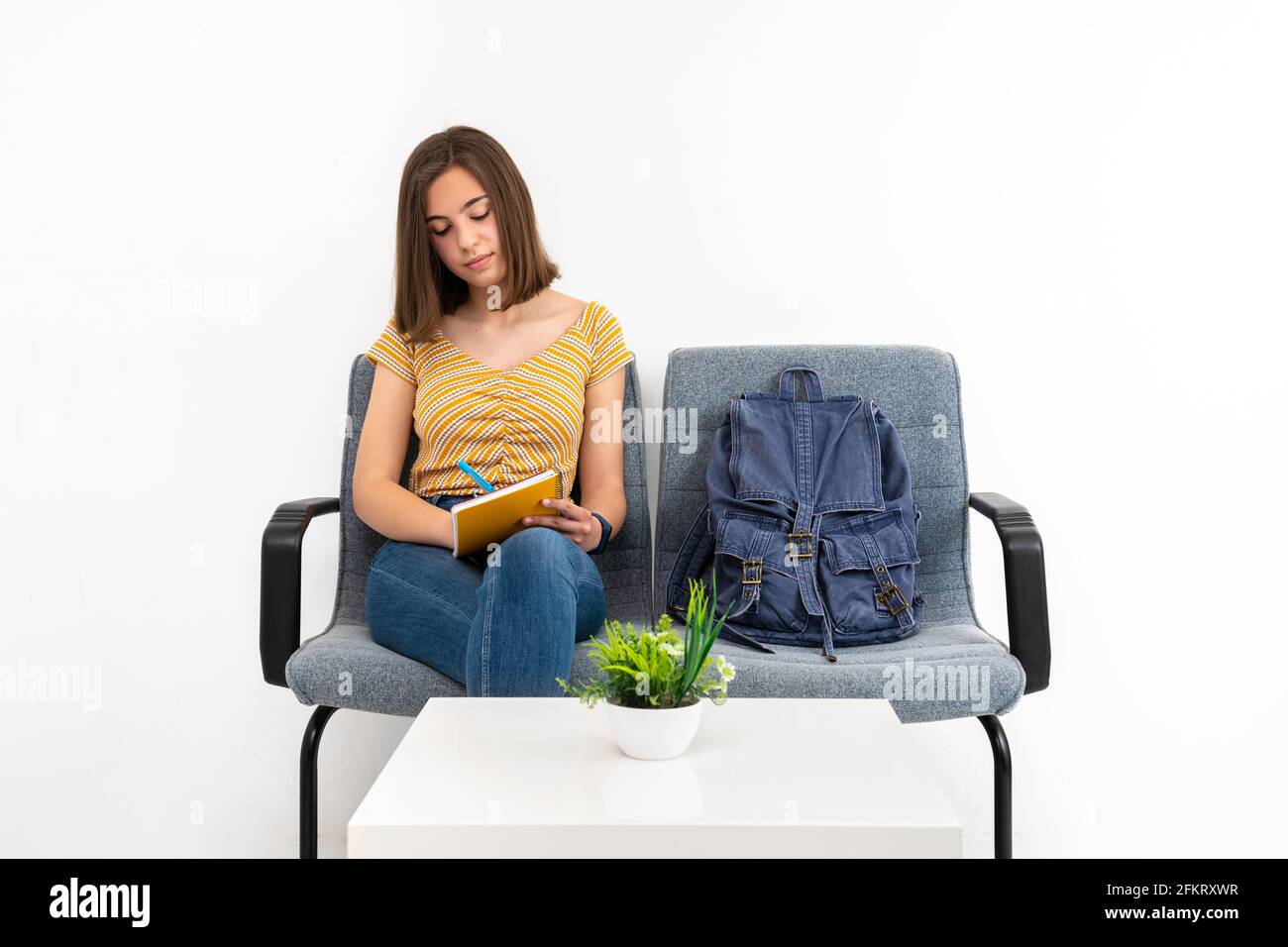 Young female client in the waiting room studying while waiting on a ...
