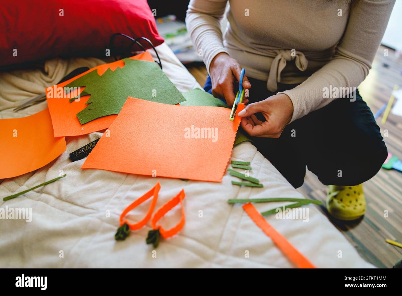 Hands of unknown woman holding scissors cutting material at home while ...