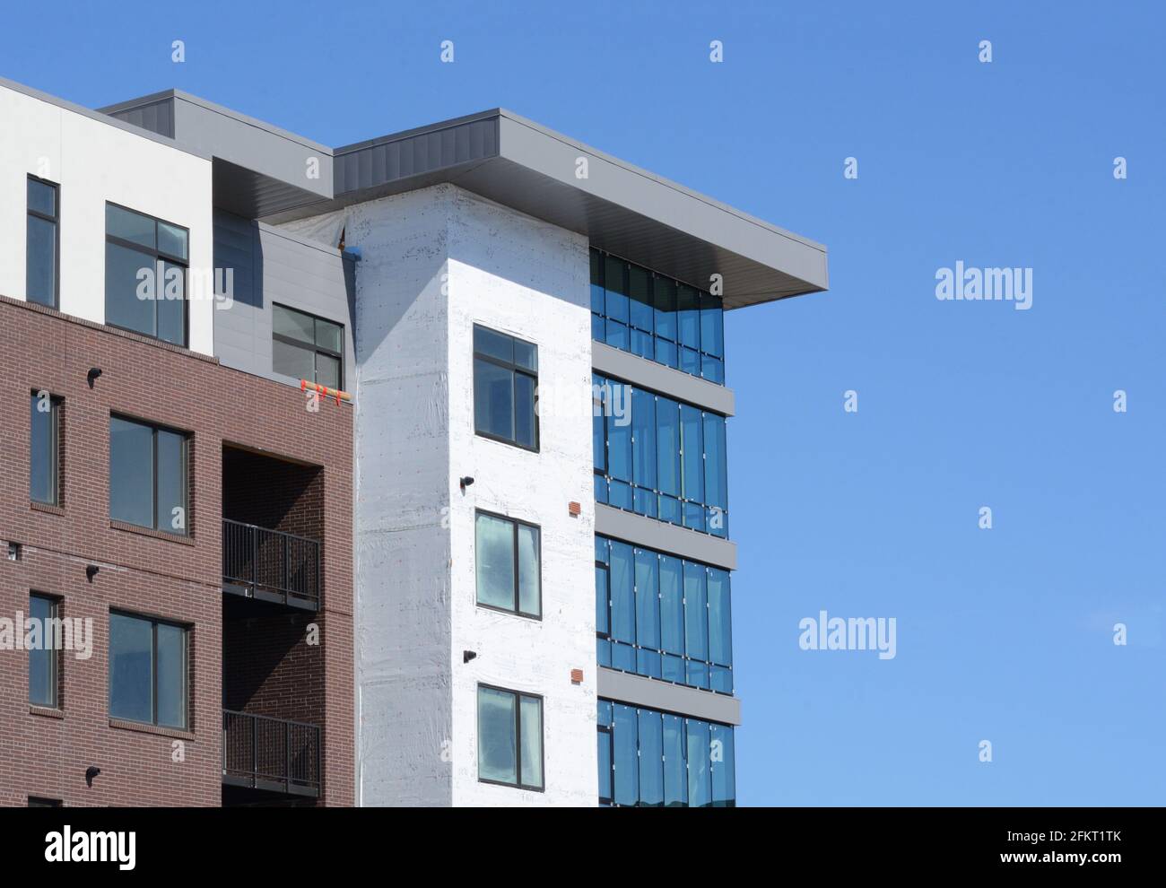 Construction of new building with windows and wrap still on exterior ...