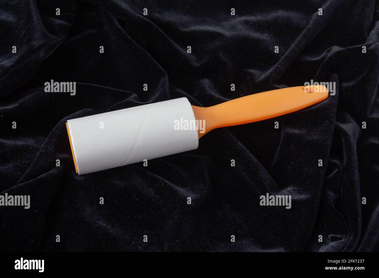 Sticky cleaner from wool and dust for clothes on black dusty velvet ...